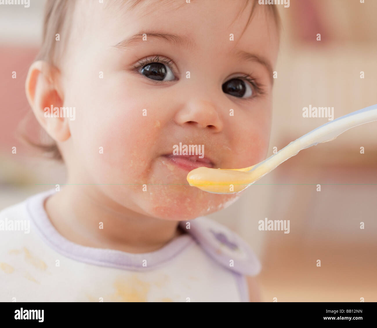 Mixed race baby girl eating Stock Photo - Alamy