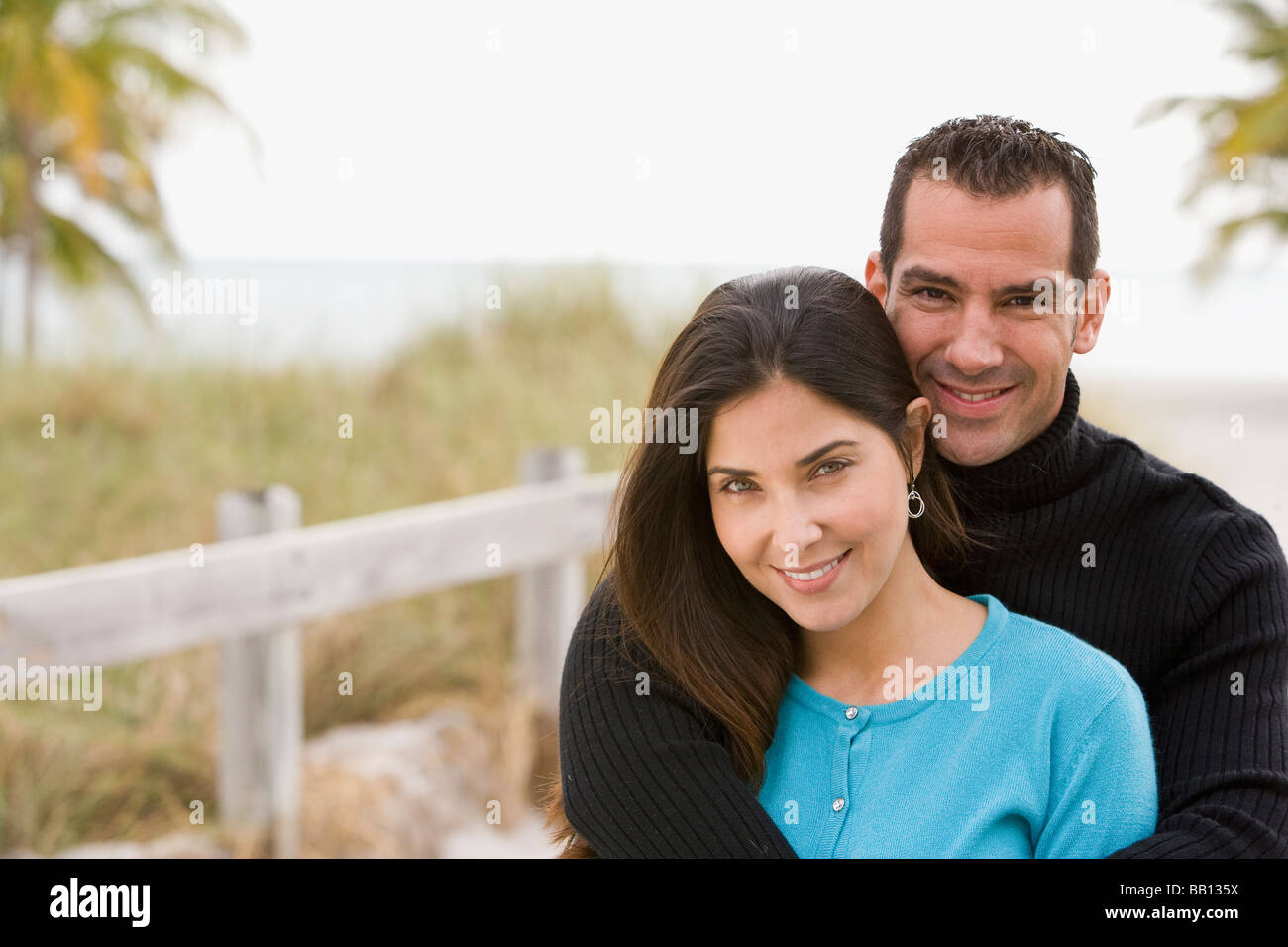 Hispanic couple hugging near ocean Stock Photo - Alamy