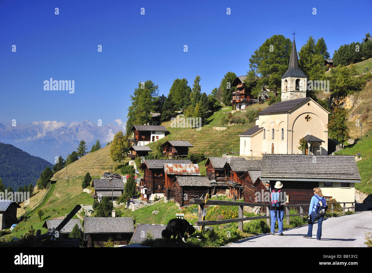 A view of Chandolin with its church. Two hikers admiring the view Stock ...