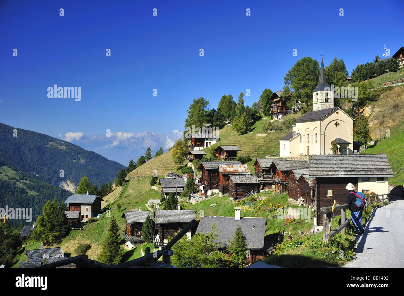 A view of Chandolin with its church. Two hikers admiring the view Stock ...