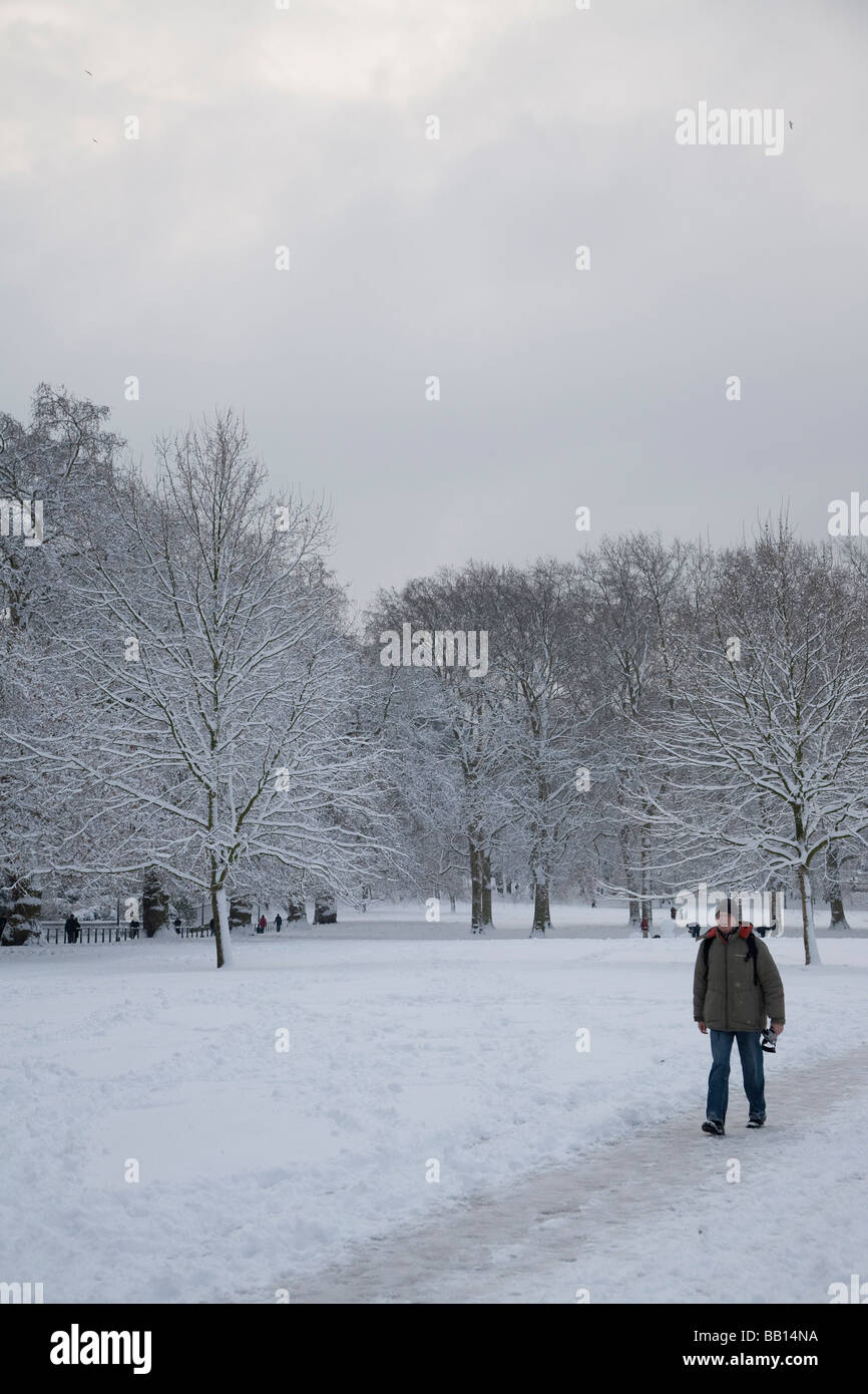 Man walking through snow covered park, London Stock Photo - Alamy