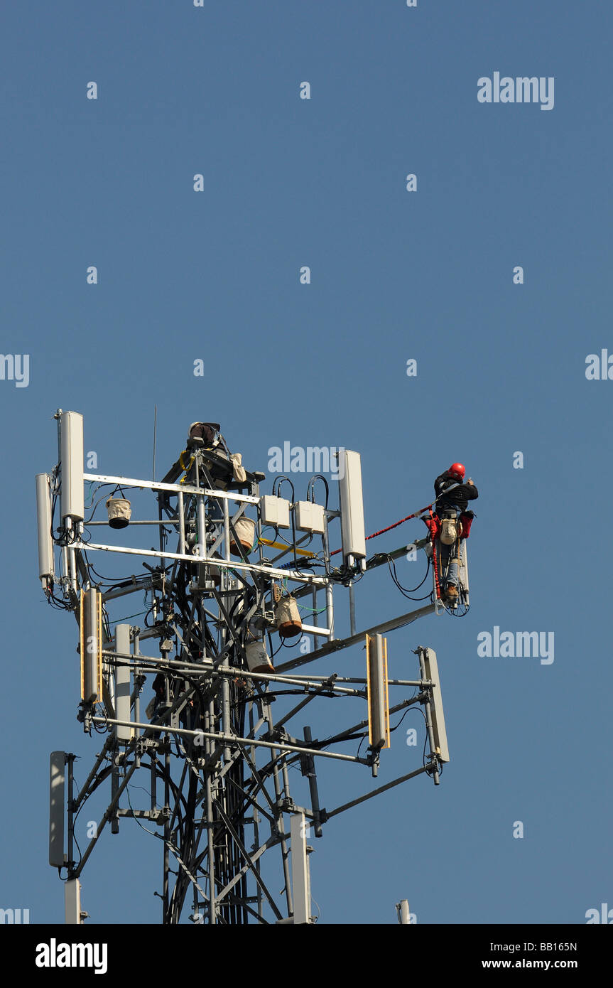 Men in safety harnesses working on cell tower Stock Photo - Alamy