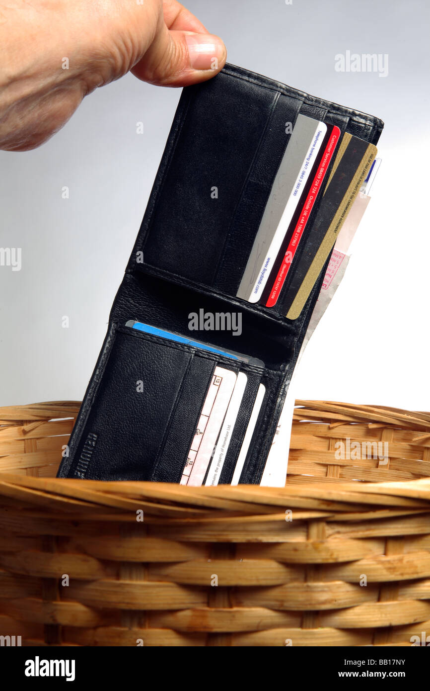 Wallet dropping into waste basket Stock Photo - Alamy