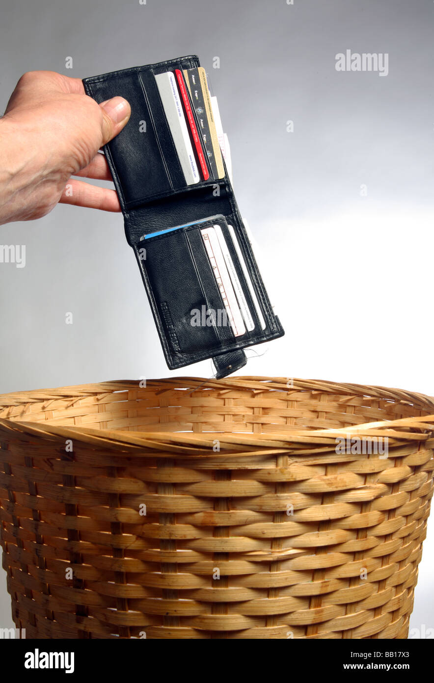 Wallet dropping into waste basket Stock Photo - Alamy