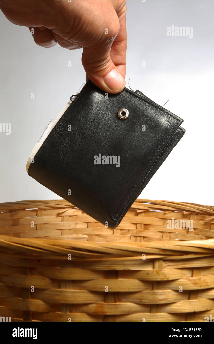 Wallet dropping into waste basket Stock Photo - Alamy