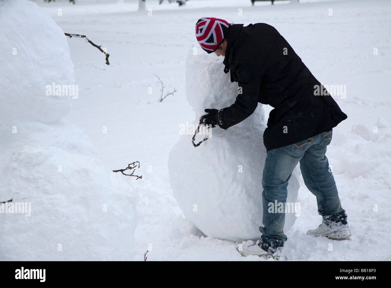 Man making a snowman Stock Photo - Alamy