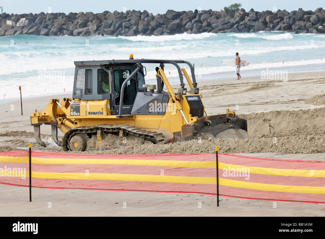 Earthmoving bulldozer moving sand to prevent beach erosion Stock Photo ...