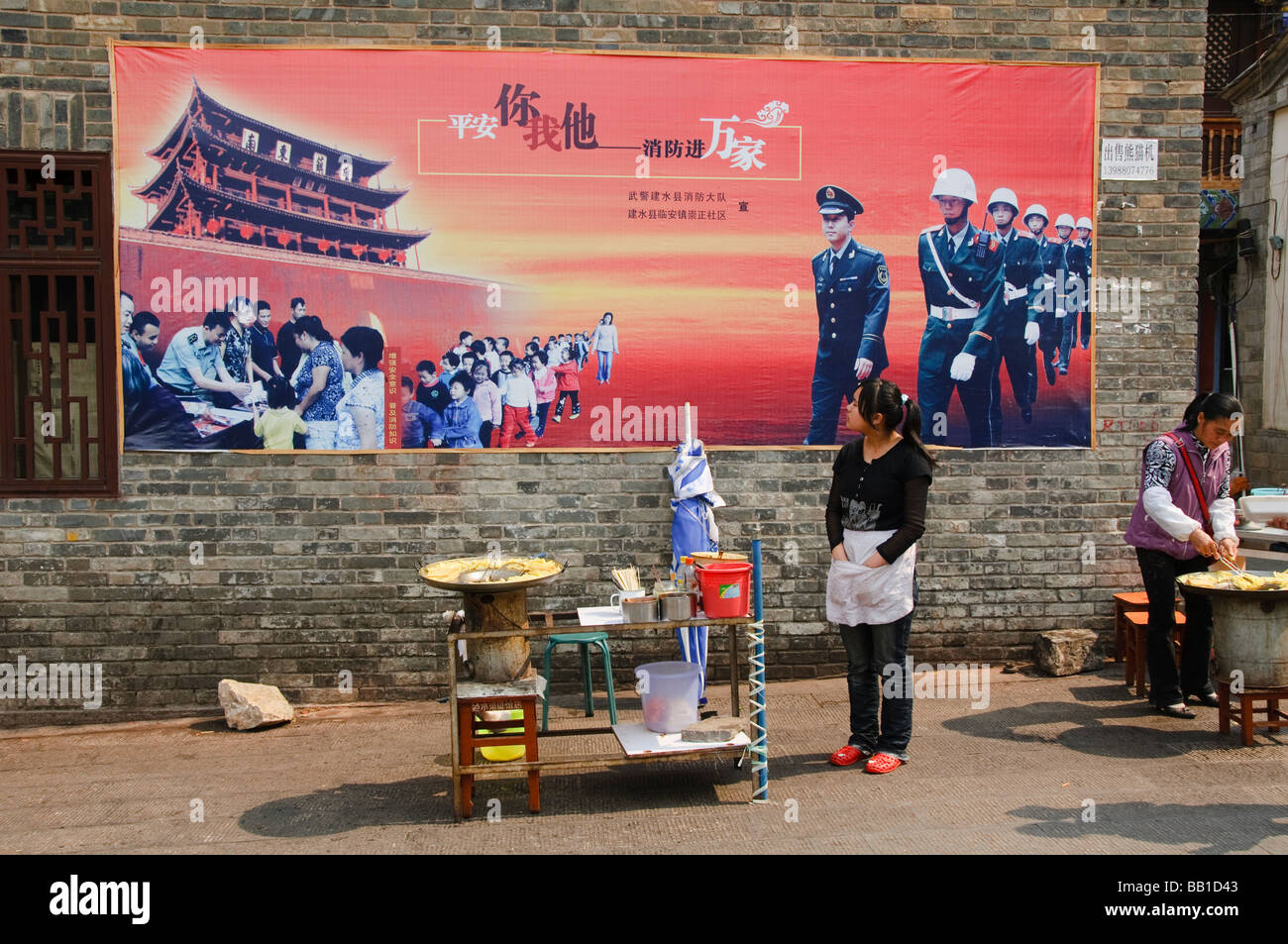 government propaganda mural over street vendor in Jianshui China Stock ...