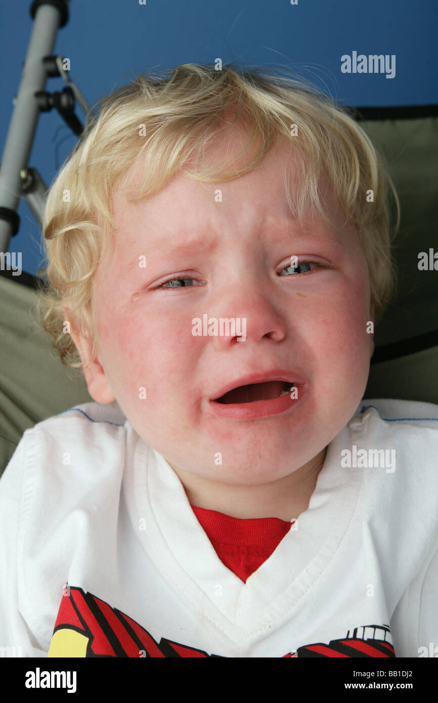 Blonde haired child crying with tears in his eyes Stock Photo - Alamy