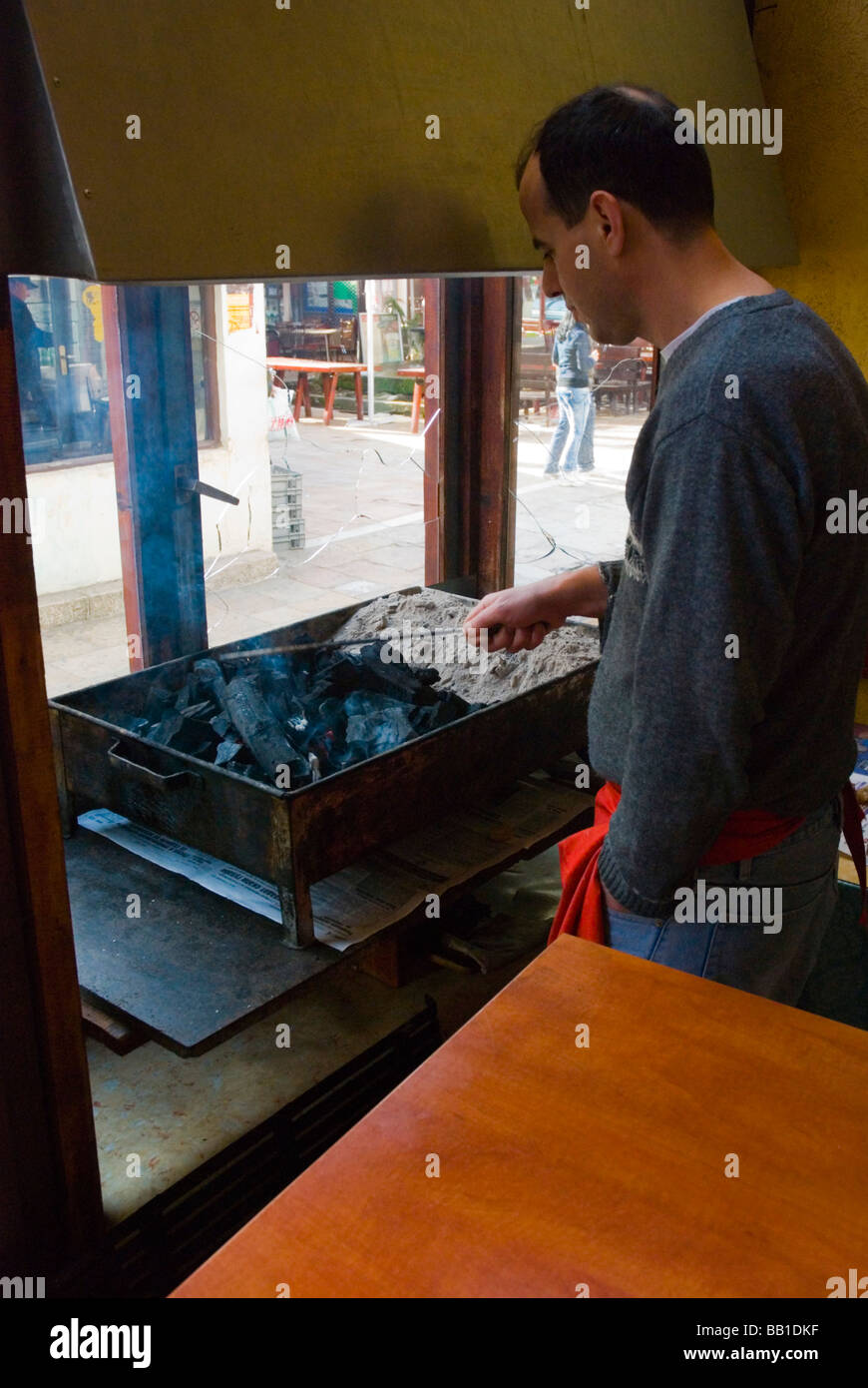 Man lighting up skara barbecue grill in a restaurant in Carsija ...
