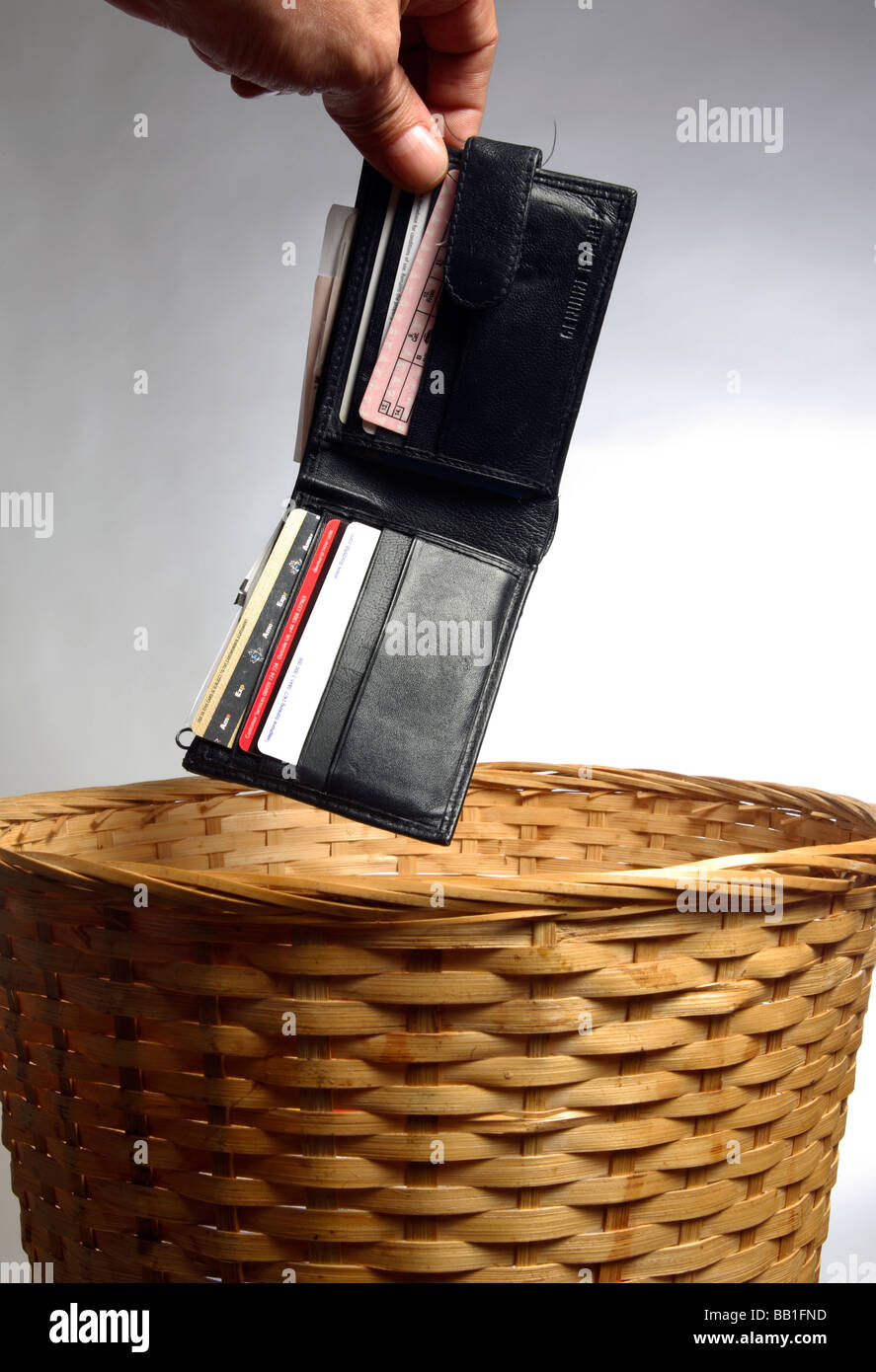 Wallet dropping into waste basket Stock Photo - Alamy