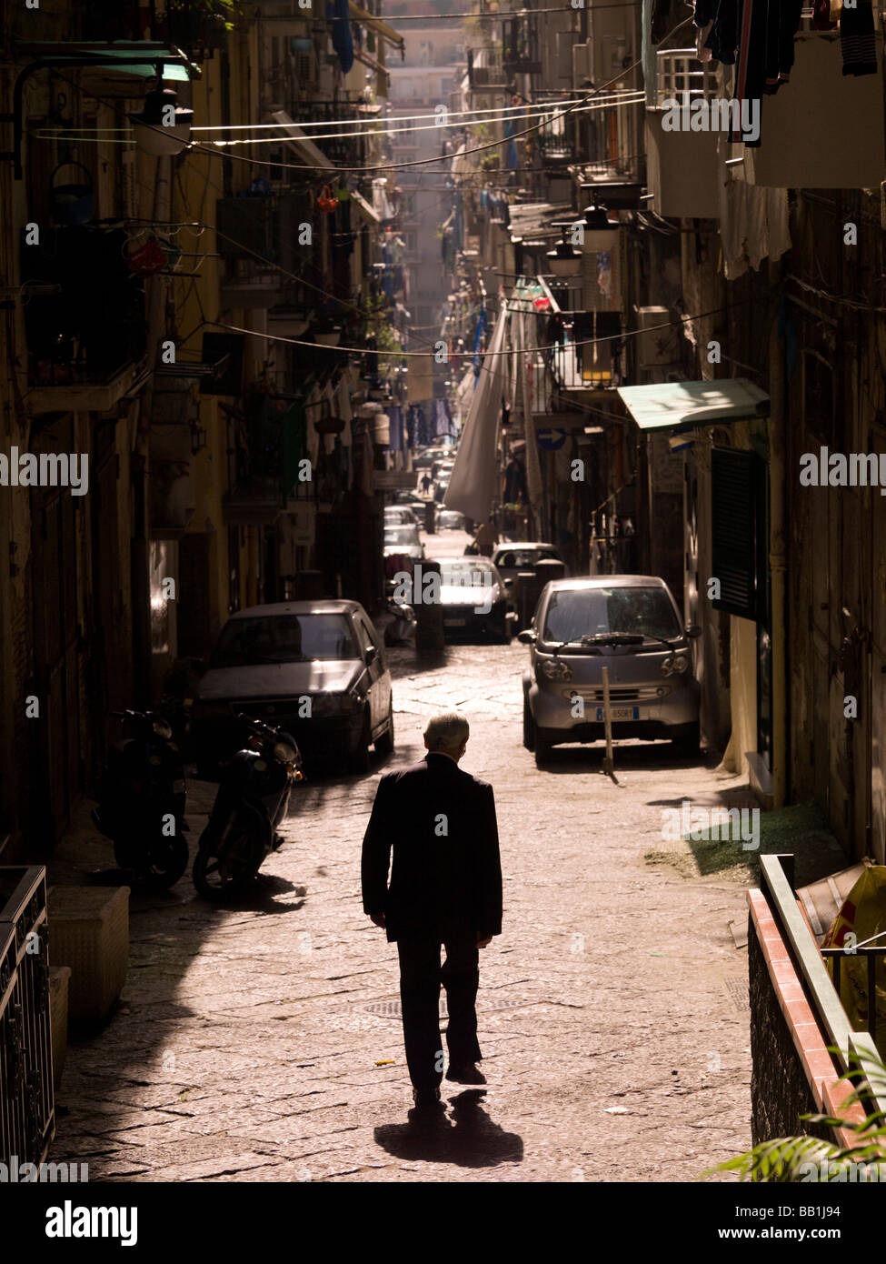 Man walking on street of historic old town, rear view; Naples, Italy ...