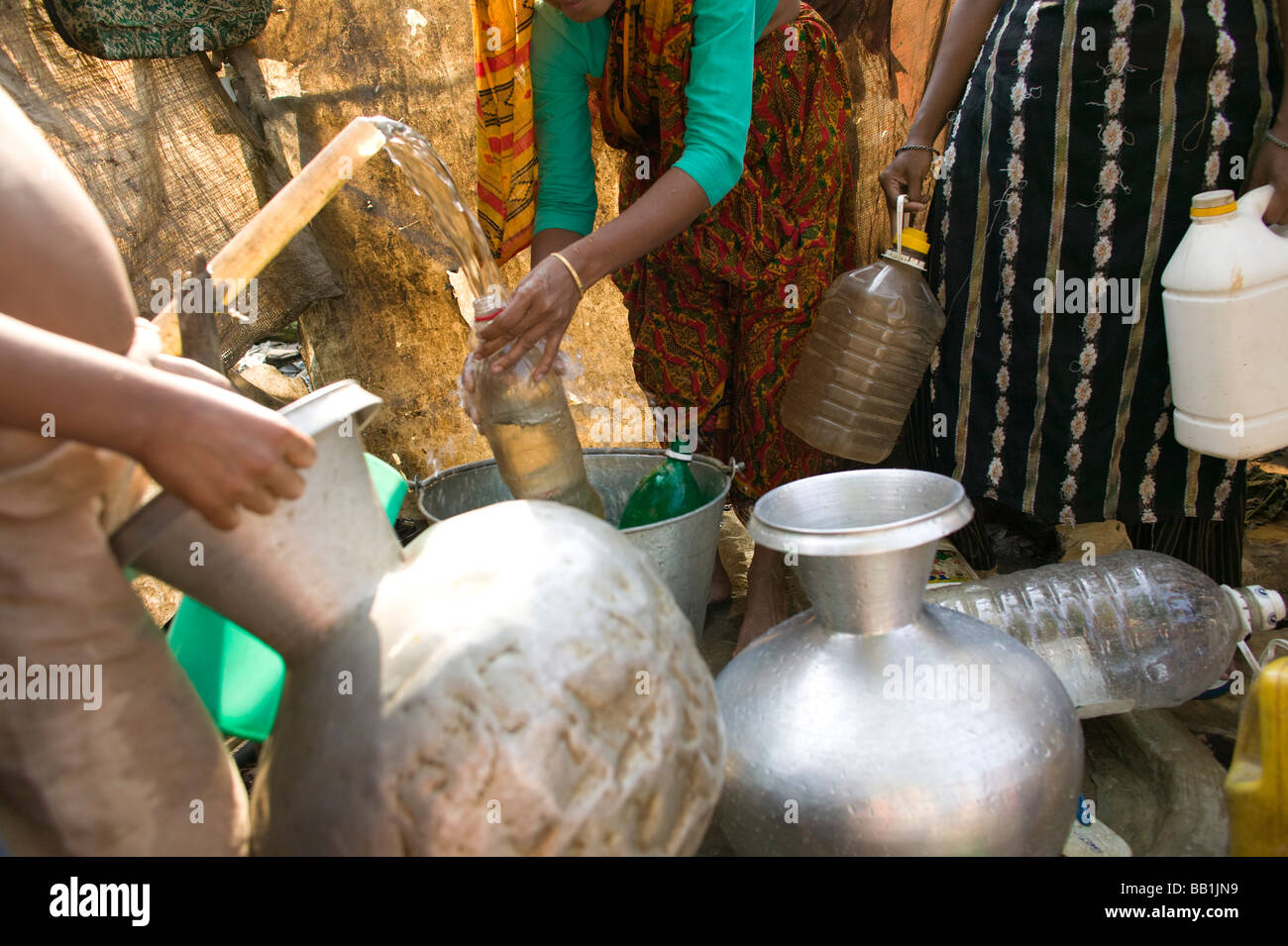 Women collecting water from pipe, Sukrabad, outside of Dhaka ...