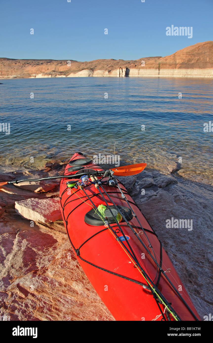 a sea kayak loaded with fishng rods sits on the bank of Lake Powell ...