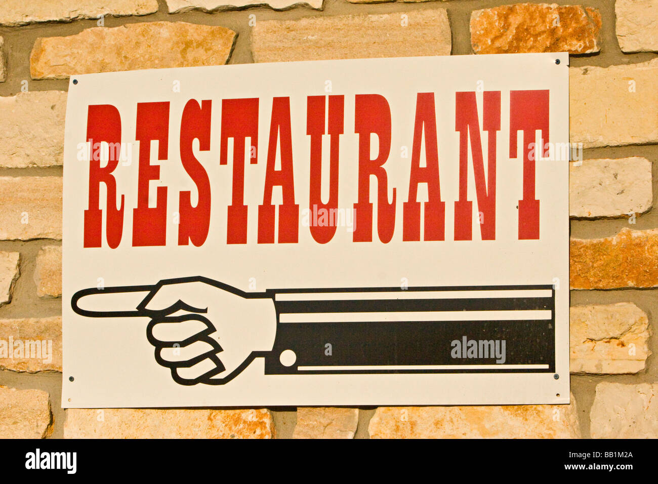 Restaurant sign with arm and hand pointing to entrance door Stock Photo ...