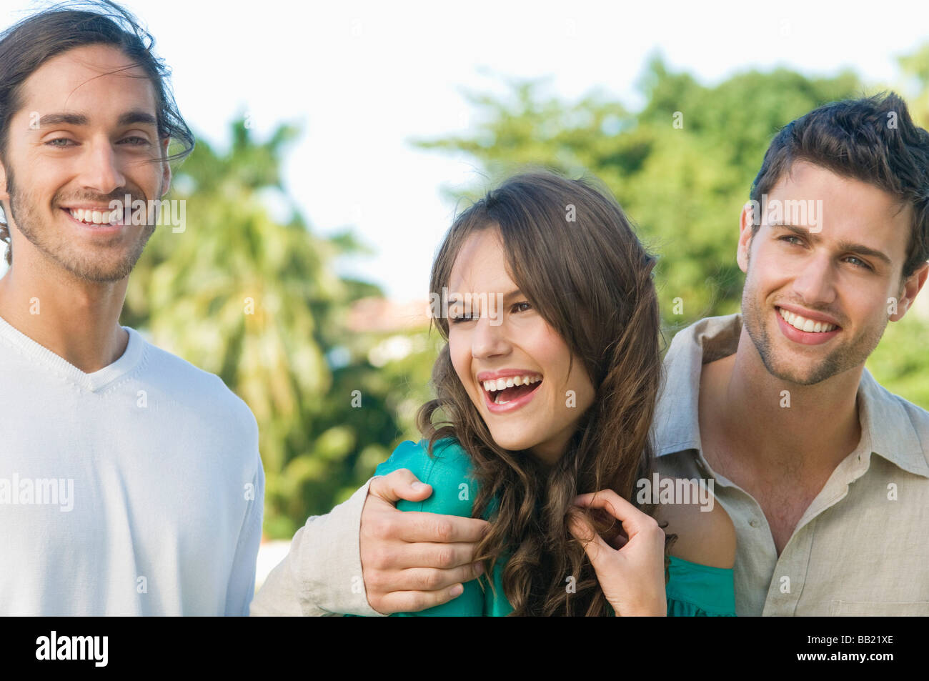 Three friends smiling Stock Photo - Alamy