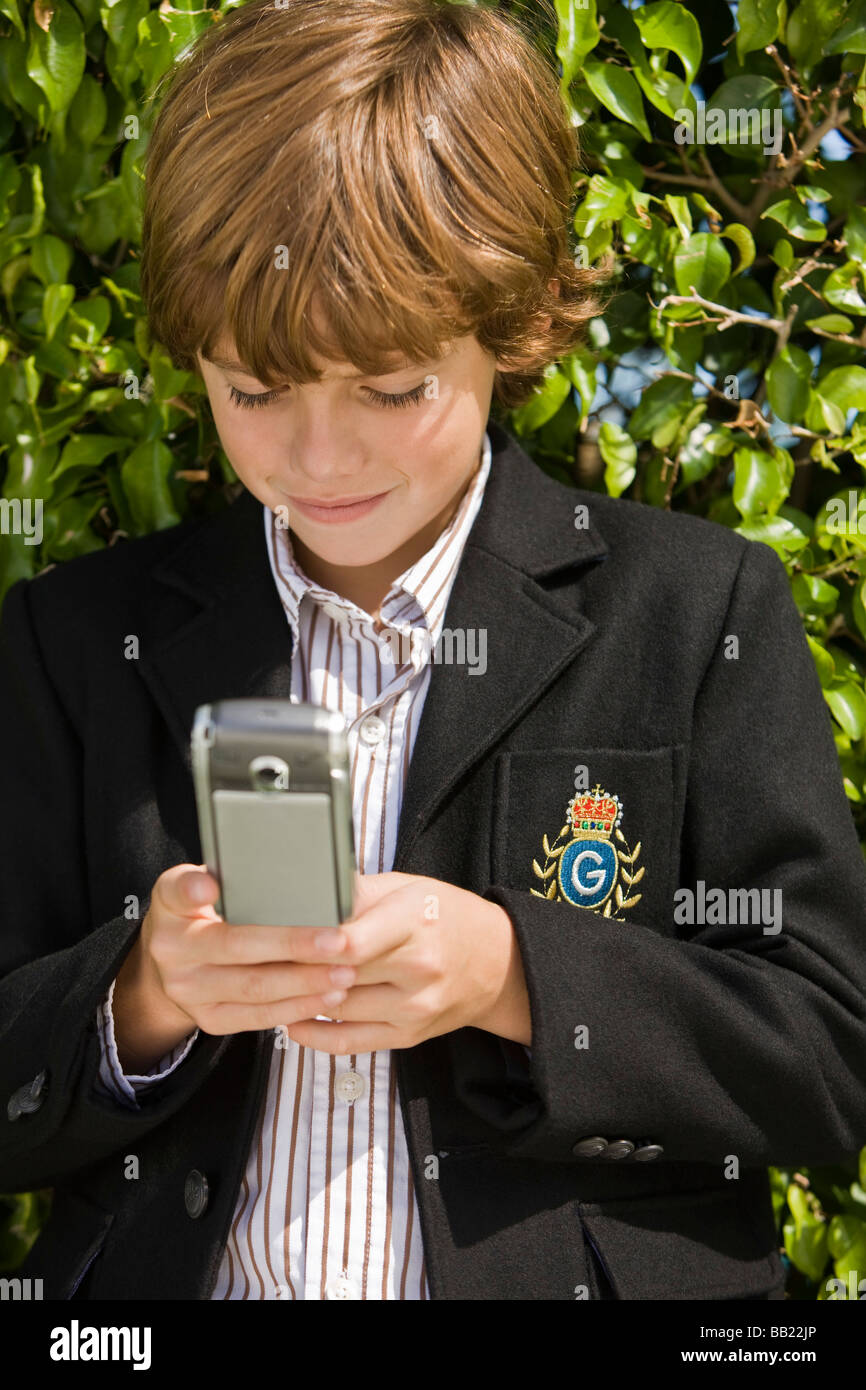 Boy text messaging with a mobile phone Stock Photo - Alamy