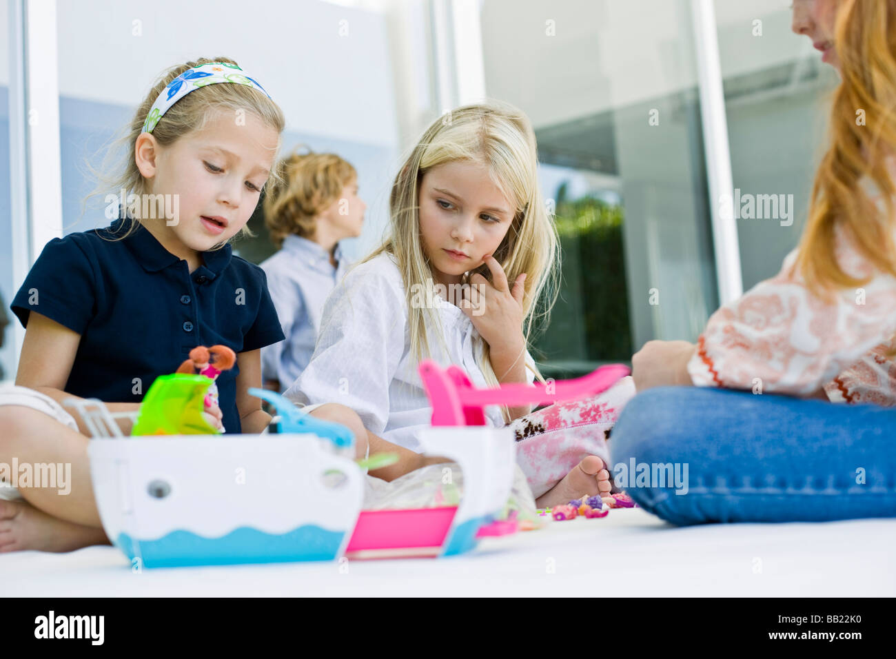 Three girls playing with toys Stock Photo - Alamy