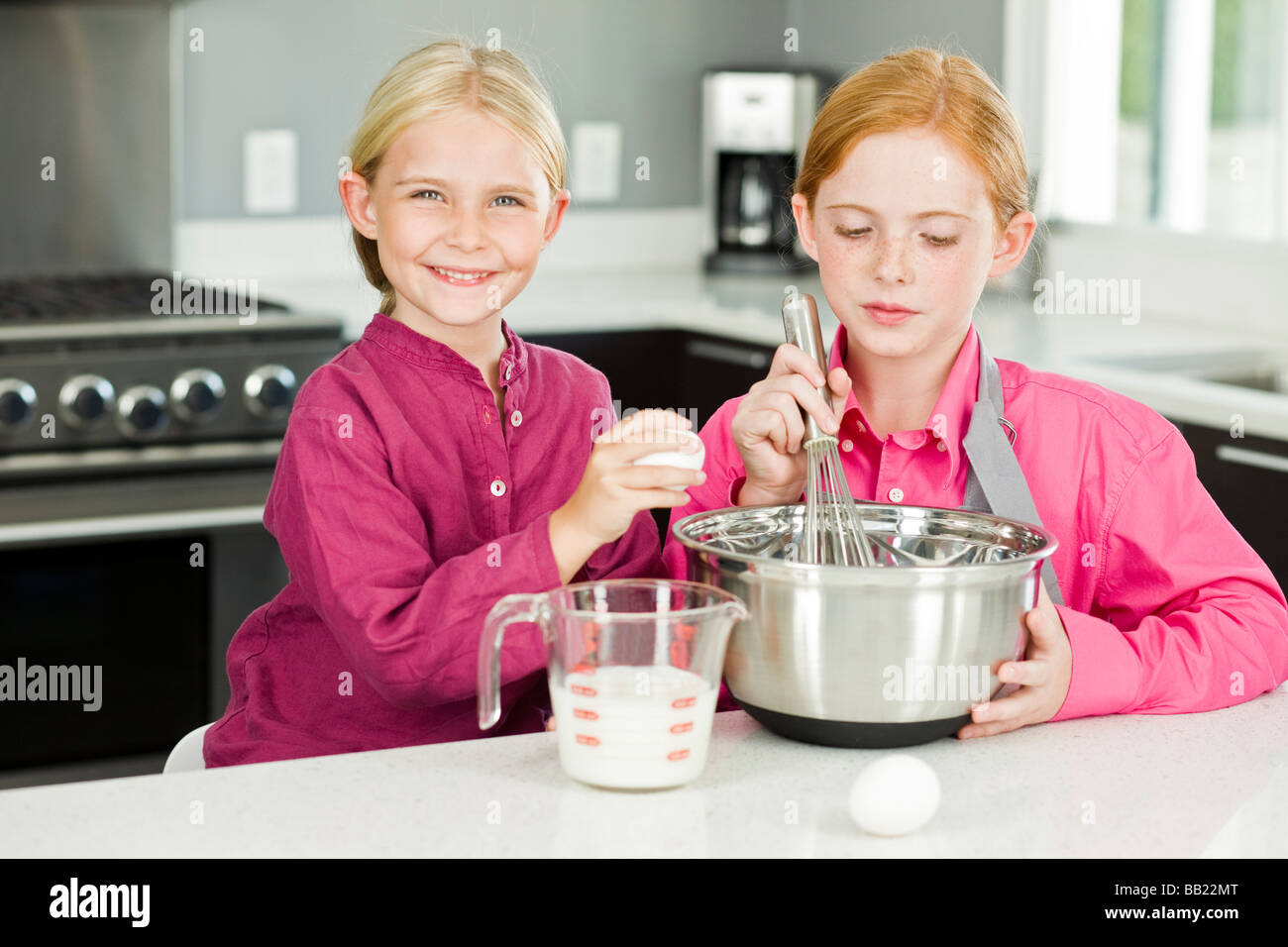 Two girls cooking food in the kitchen Stock Photo - Alamy