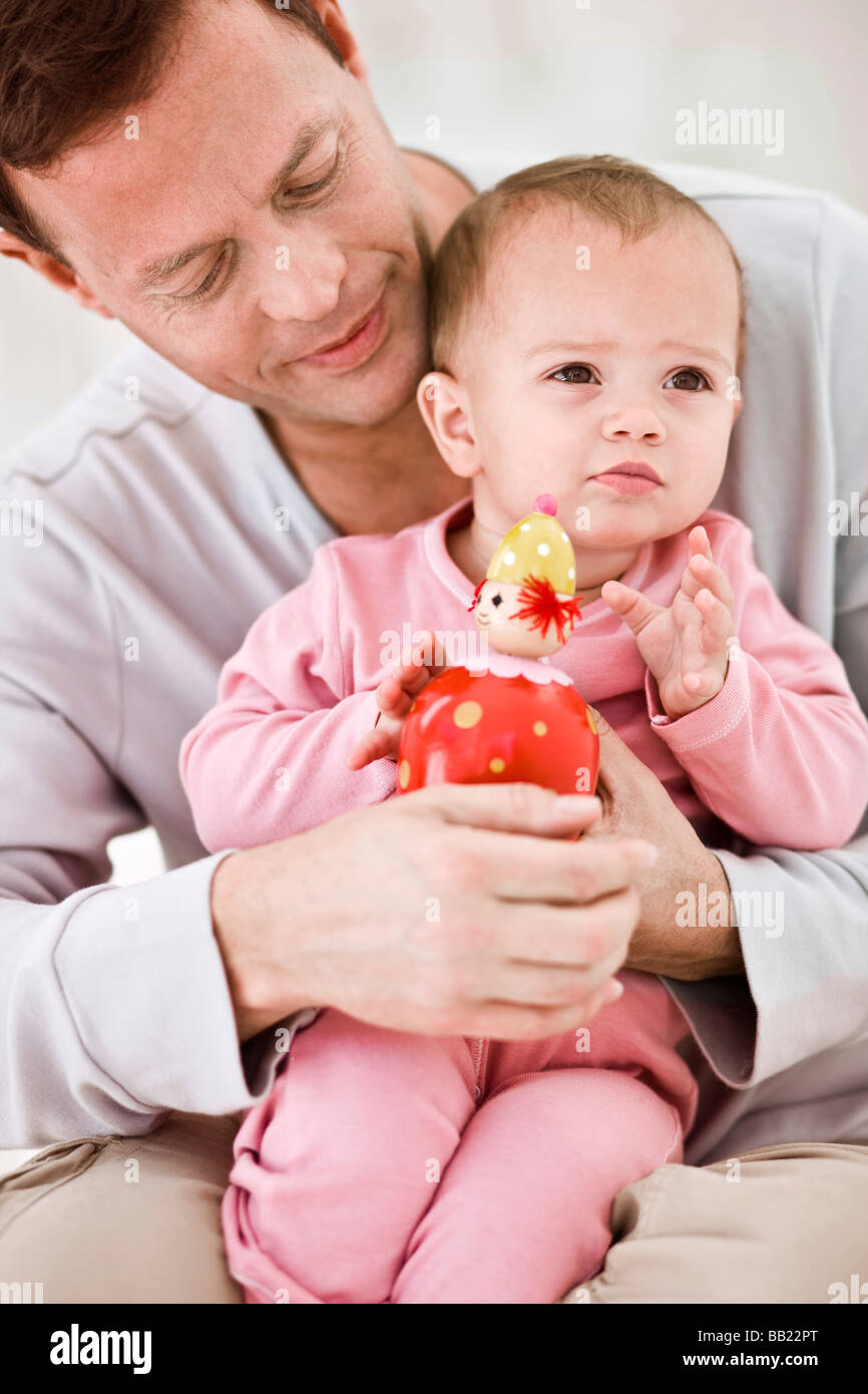 Baby girl sitting on her father's lap Stock Photo - Alamy