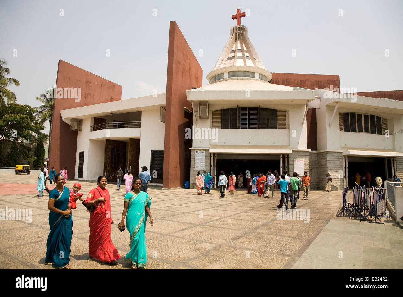 Indian women in saris walk outside of the Church of the Infant Jesus in ...