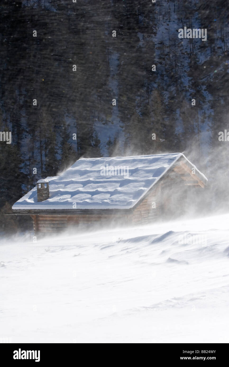 Wind blowing snow off mountain hut, or log cabin, Alto Adige, Italian ...