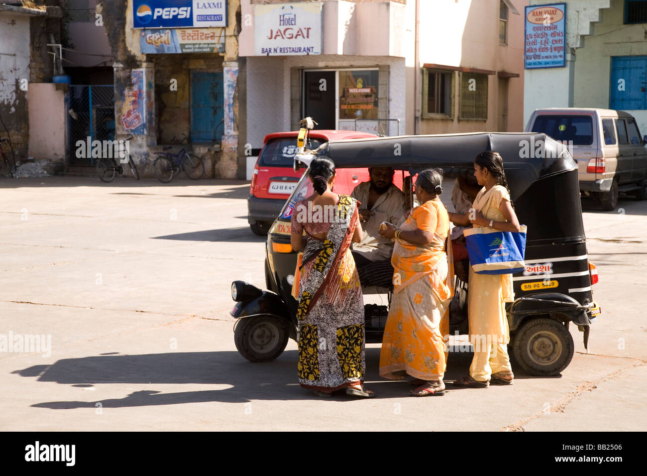 Three women pay a rickshaw driver in the former Portuguese colony of ...