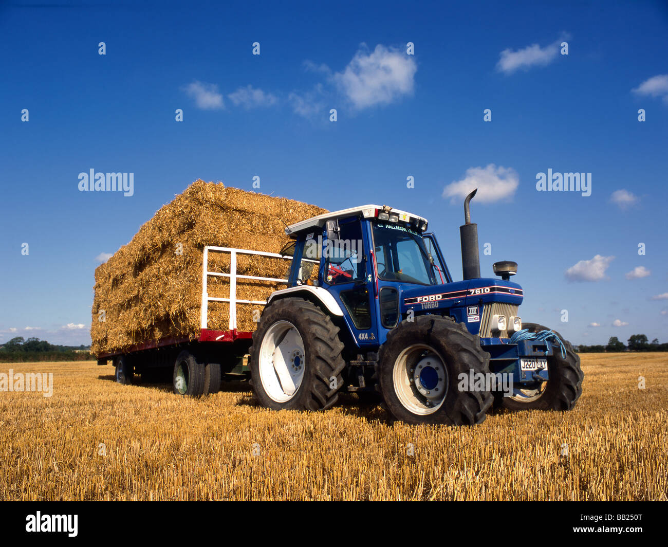 Blue ford tractor with trailer in a field in the english countryside ...