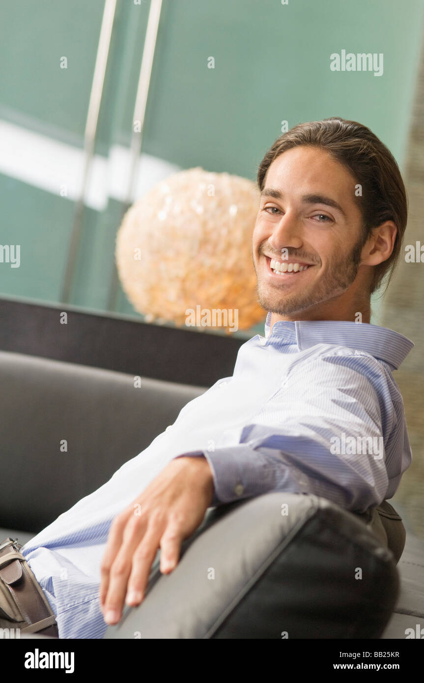 Man sitting on a couch Stock Photo - Alamy