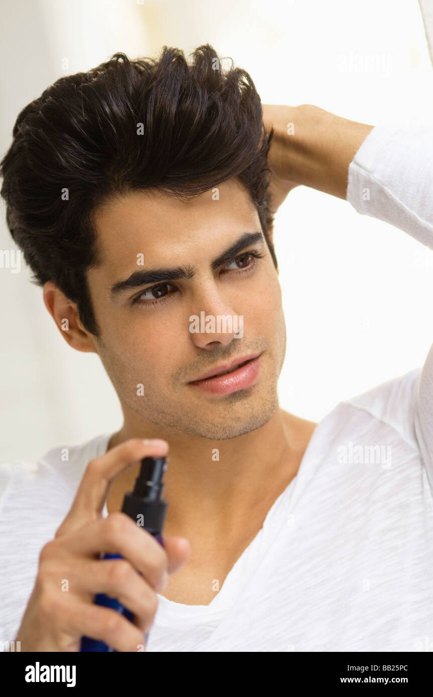 Man holding a bottle of deodorant Stock Photo - Alamy