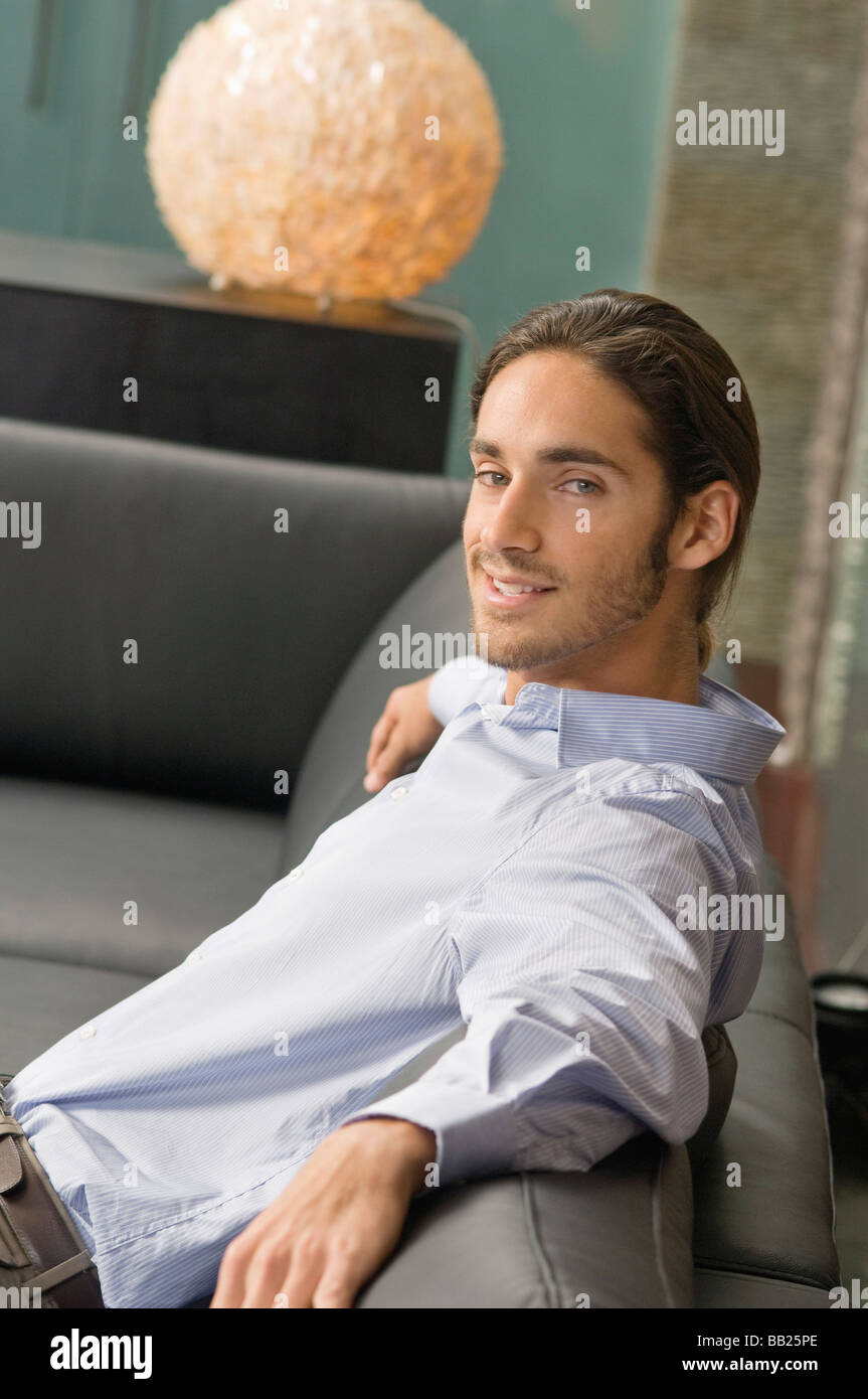 Man sitting on a couch Stock Photo - Alamy