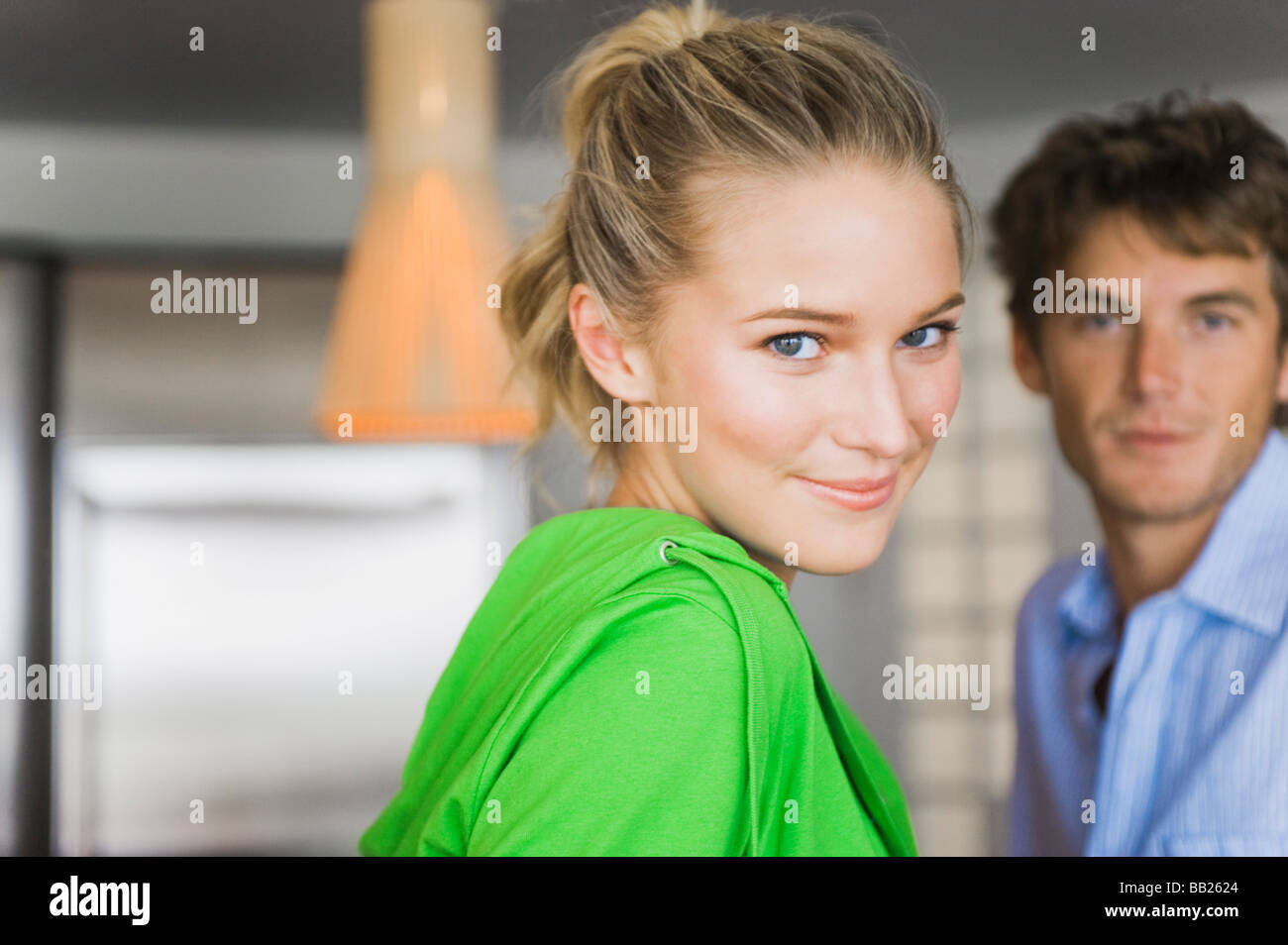 Portrait of a woman smiling with a man in the background Stock Photo ...