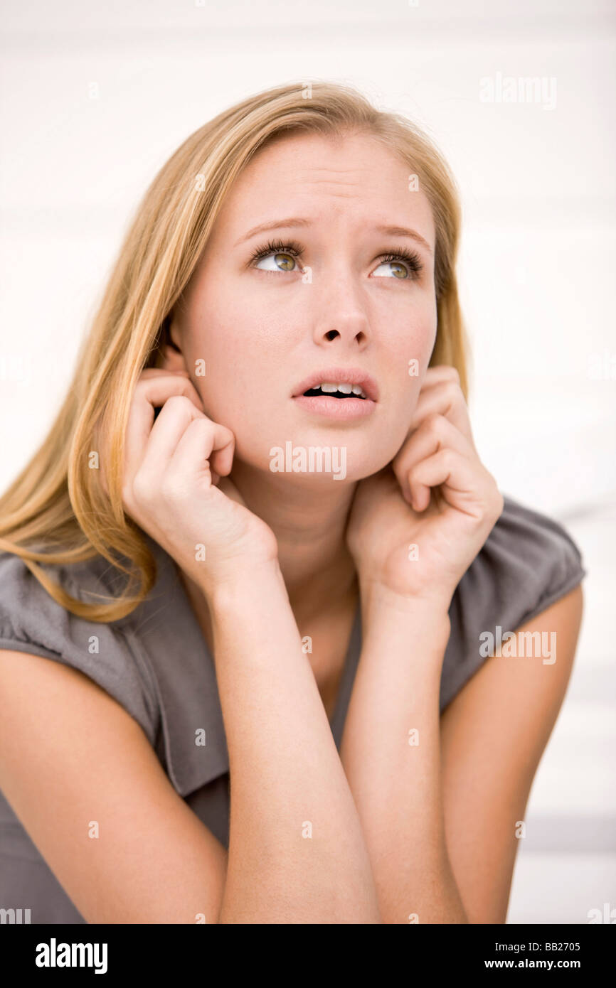 Close-up of a woman holding her ears Stock Photo - Alamy