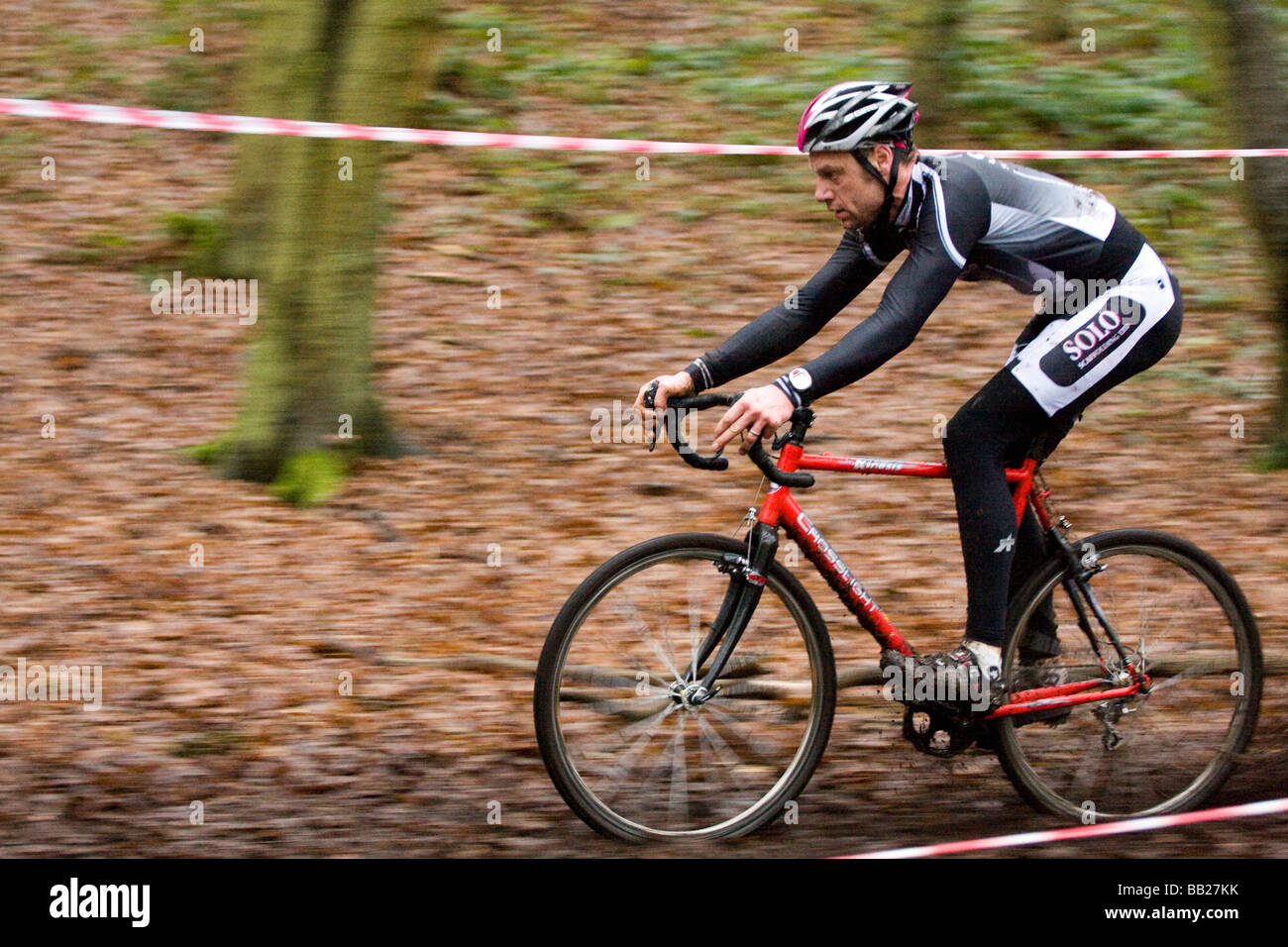 Cyclocross rider descending through leaf strewn woods Stock Photo - Alamy
