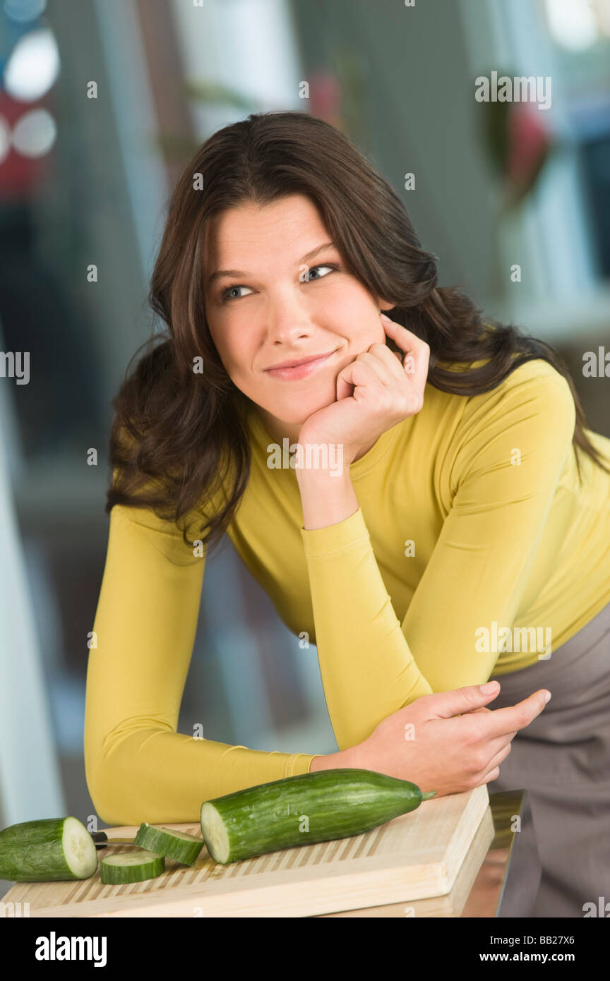 Woman leaning on a kitchen counter Stock Photo - Alamy