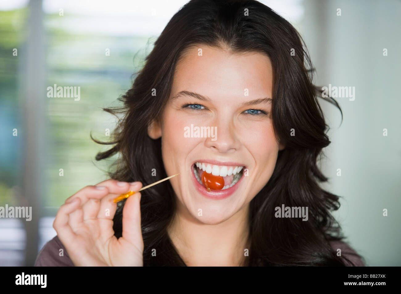 Portrait of a woman eating a berry Stock Photo - Alamy