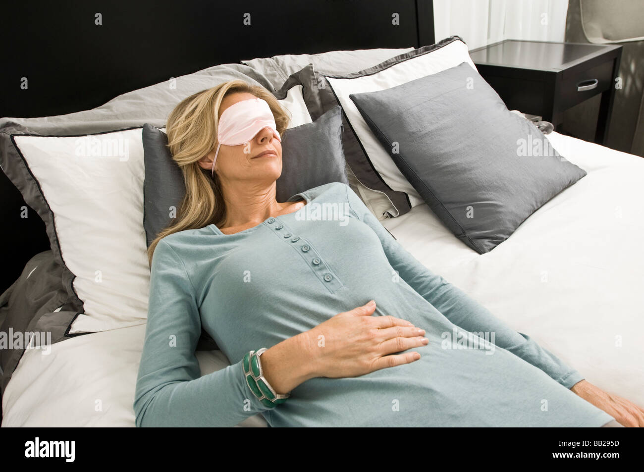 Woman sleeping in bed wearing an eye mask Stock Photo - Alamy