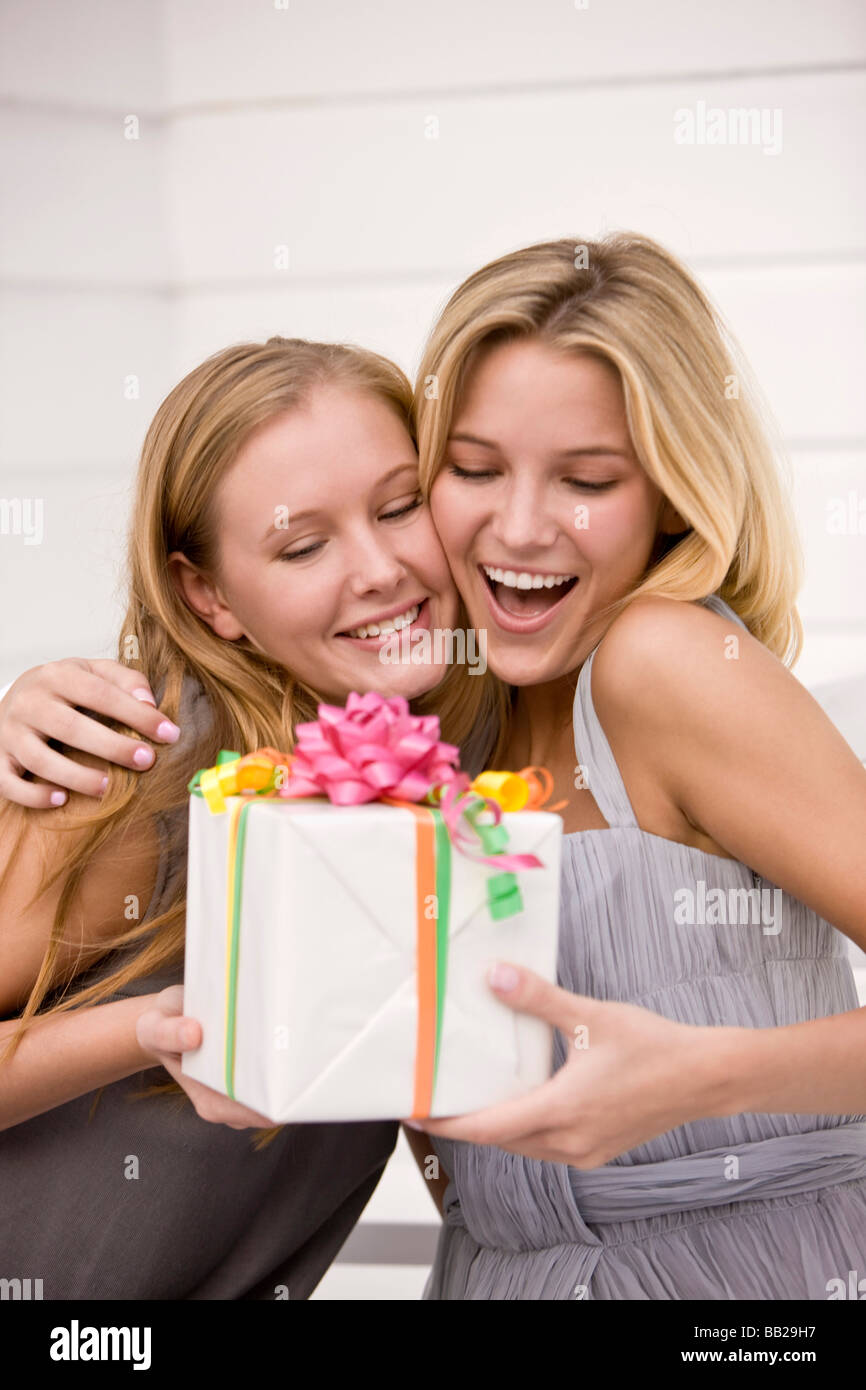 Woman giving a present to her friend Stock Photo - Alamy