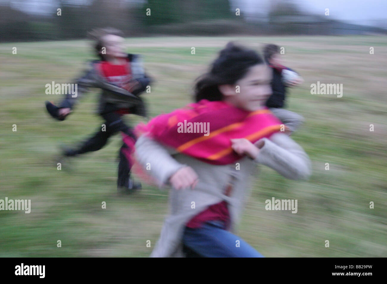 3 children sprinting across a field Stock Photo - Alamy