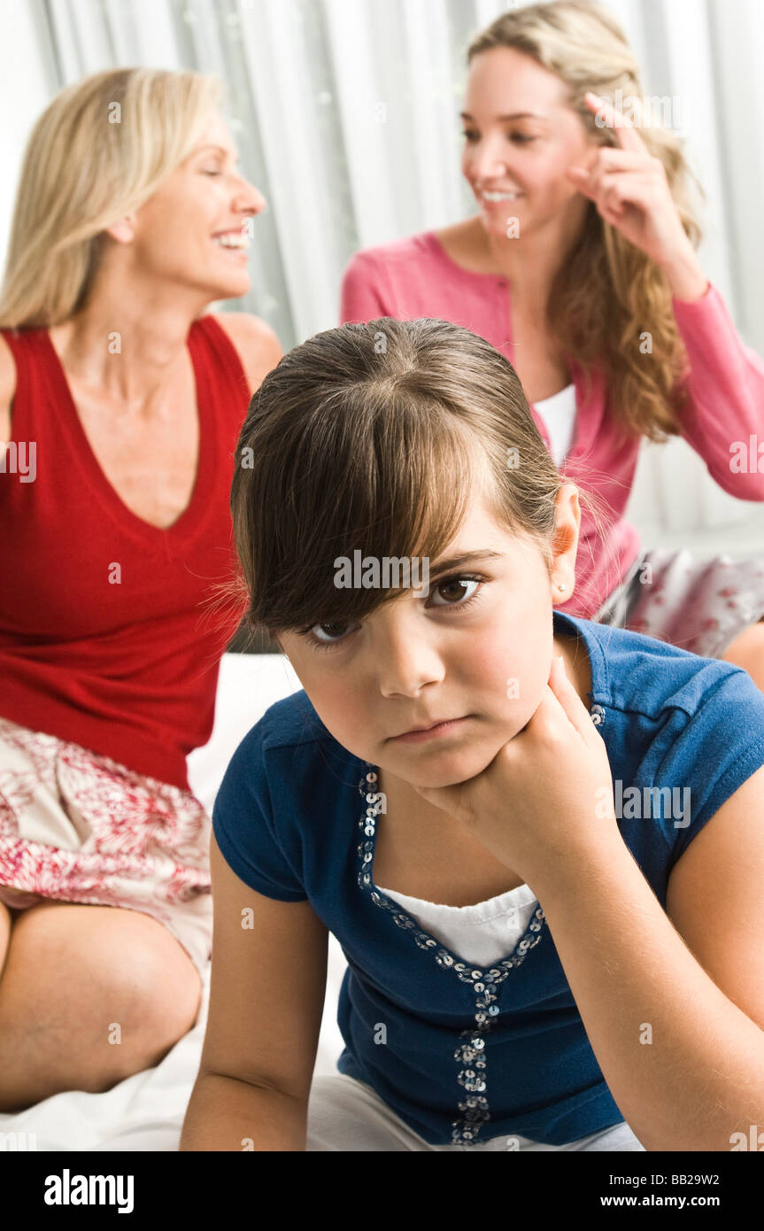 Girl looking sad with her parents sitting behind her Stock Photo - Alamy