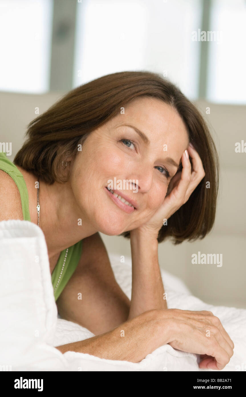 Portrait of a woman lying on a bed Stock Photo - Alamy