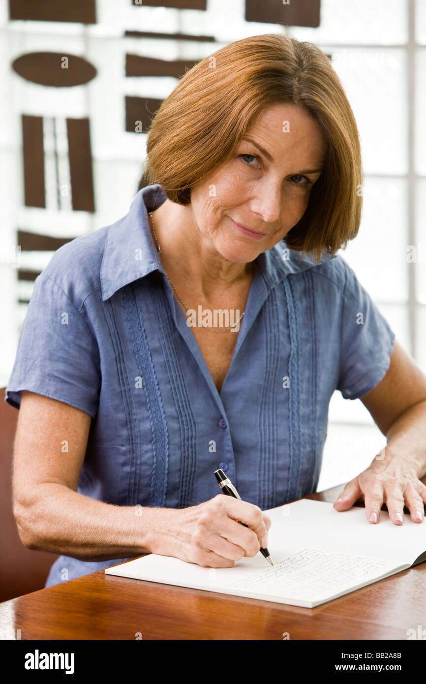 Portrait of a woman writing in a notebook Stock Photo - Alamy