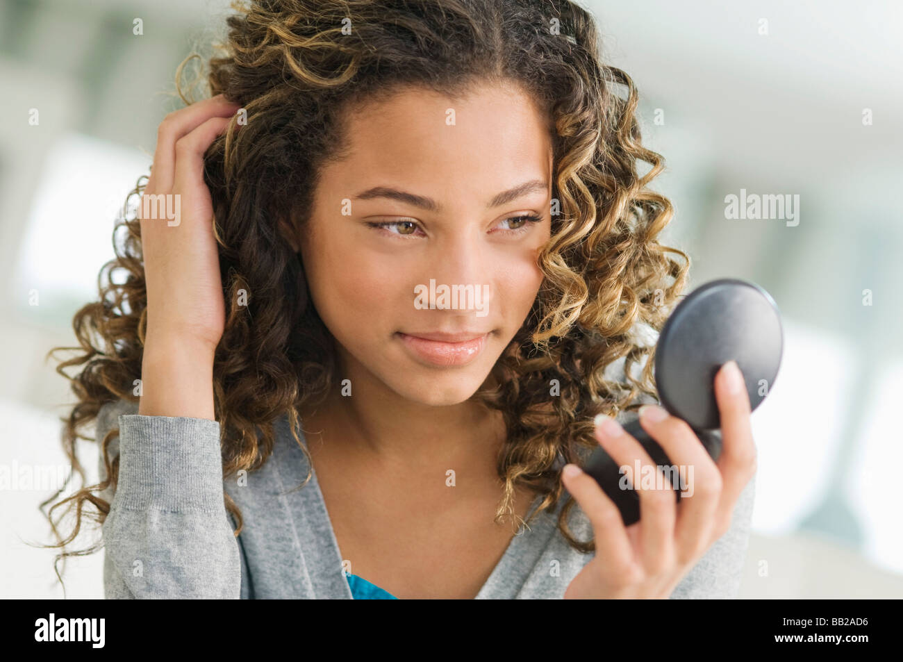 Girl looking her face in a vanity mirror Stock Photo - Alamy