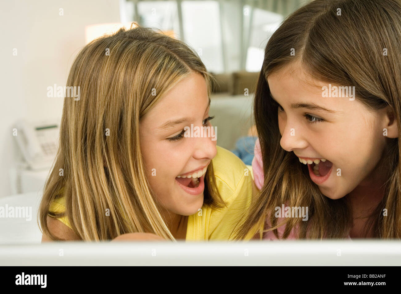 Close-up of two girls smiling at each other with a surprise Stock Photo ...