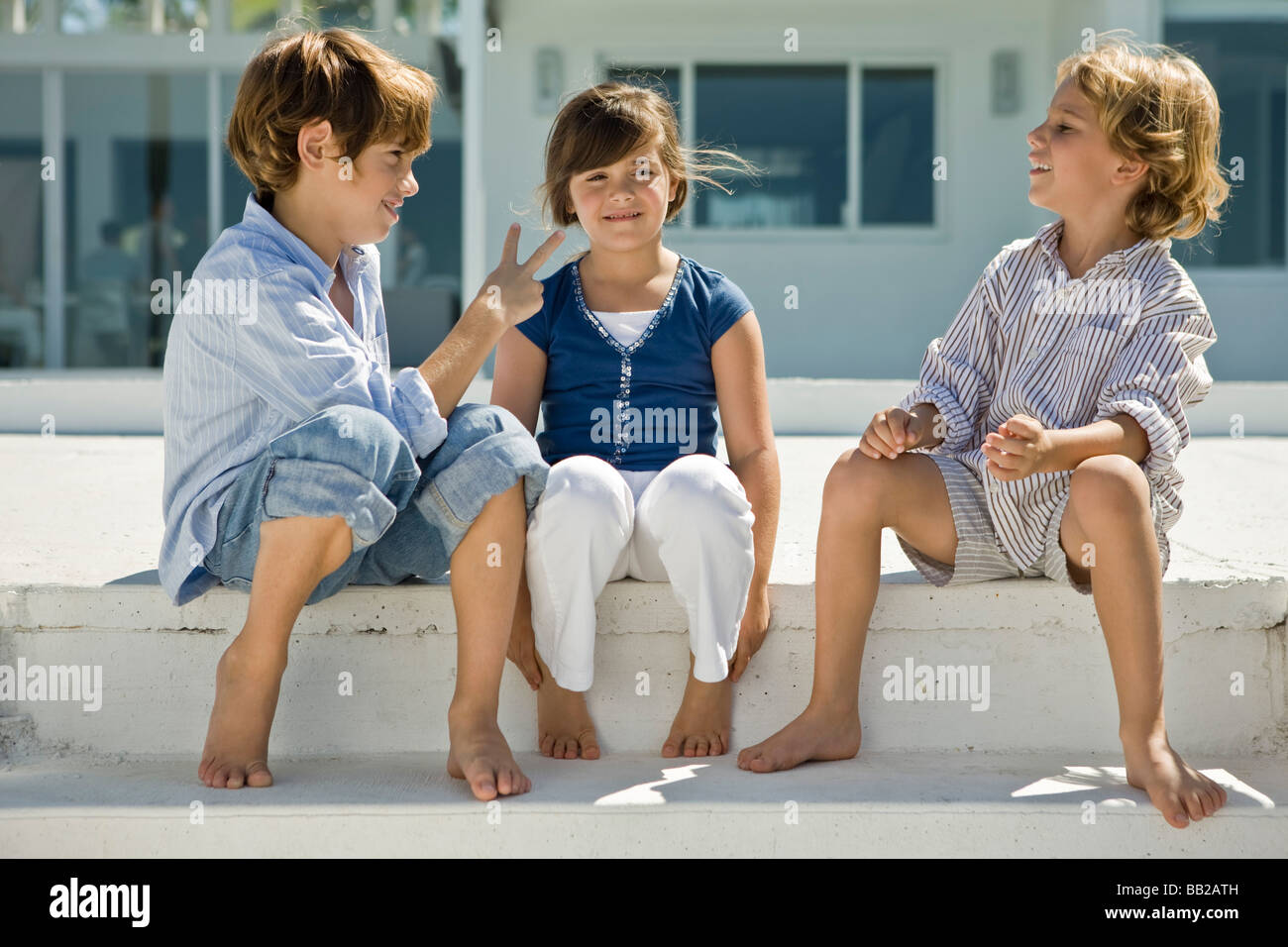 Three children sitting together Stock Photo - Alamy