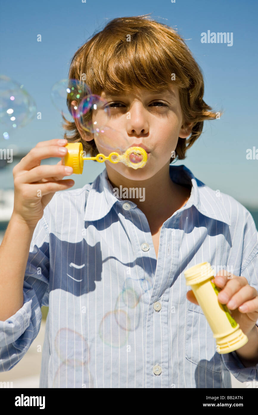 Boy blowing bubbles with a bubble wand Stock Photo - Alamy