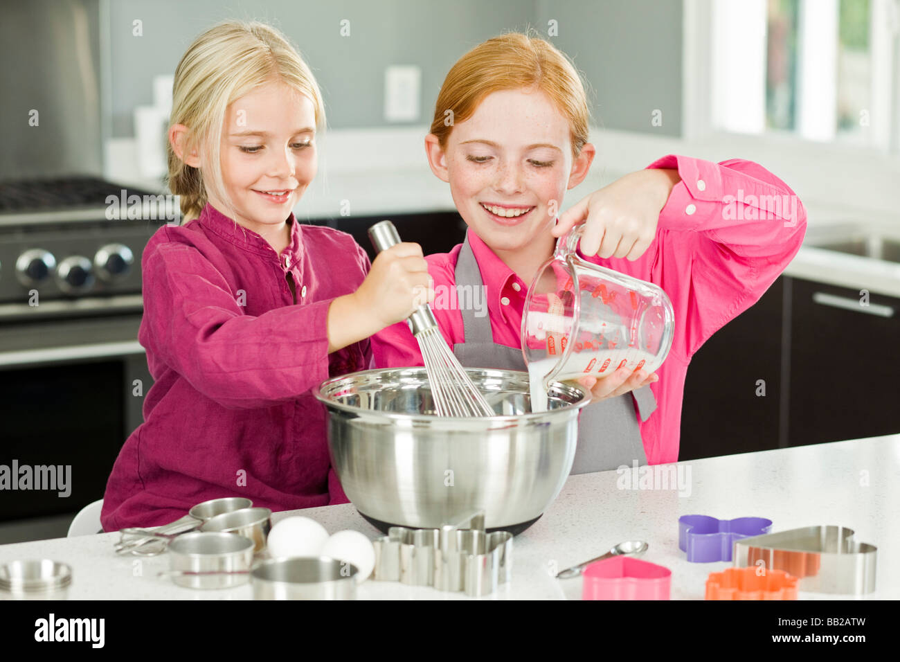 Two girls cooking food in the kitchen Stock Photo - Alamy