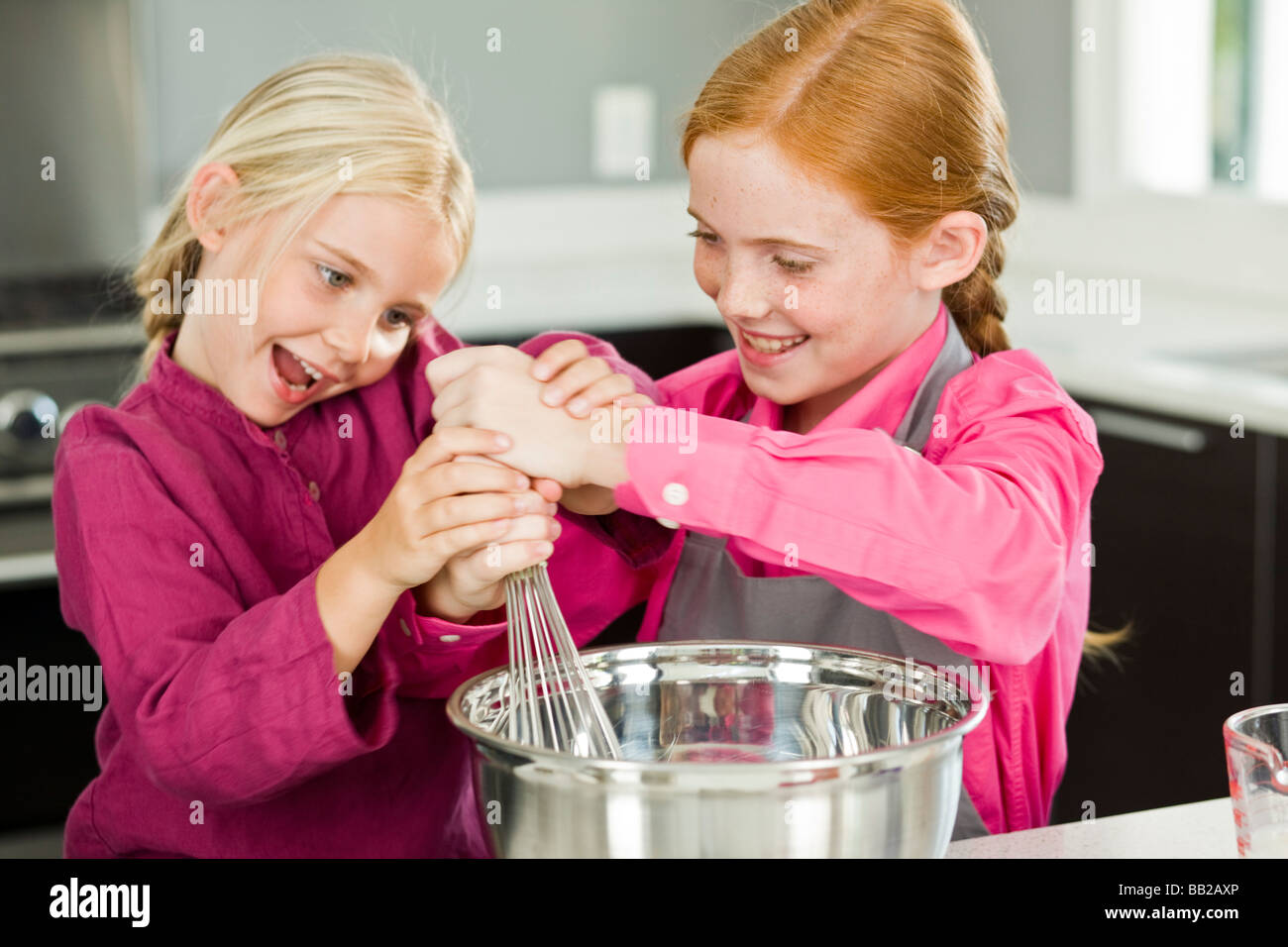 Two girls cooking food in the kitchen Stock Photo - Alamy
