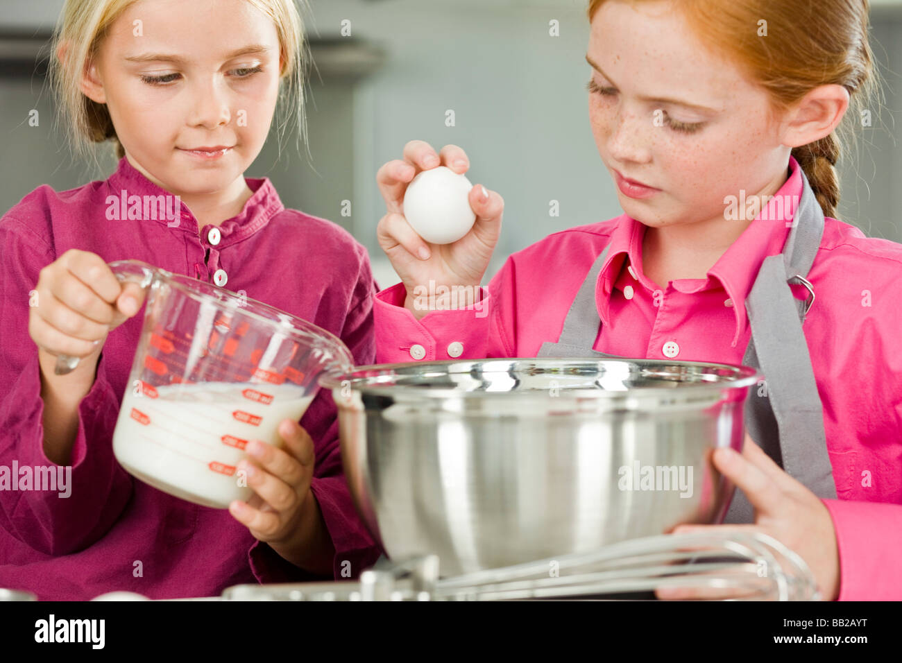 Two girls cooking food in the kitchen Stock Photo - Alamy