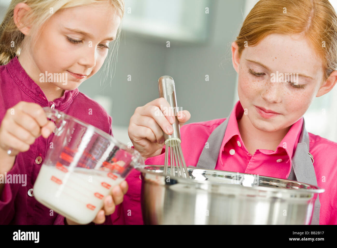 Two girls cooking food in the kitchen Stock Photo - Alamy